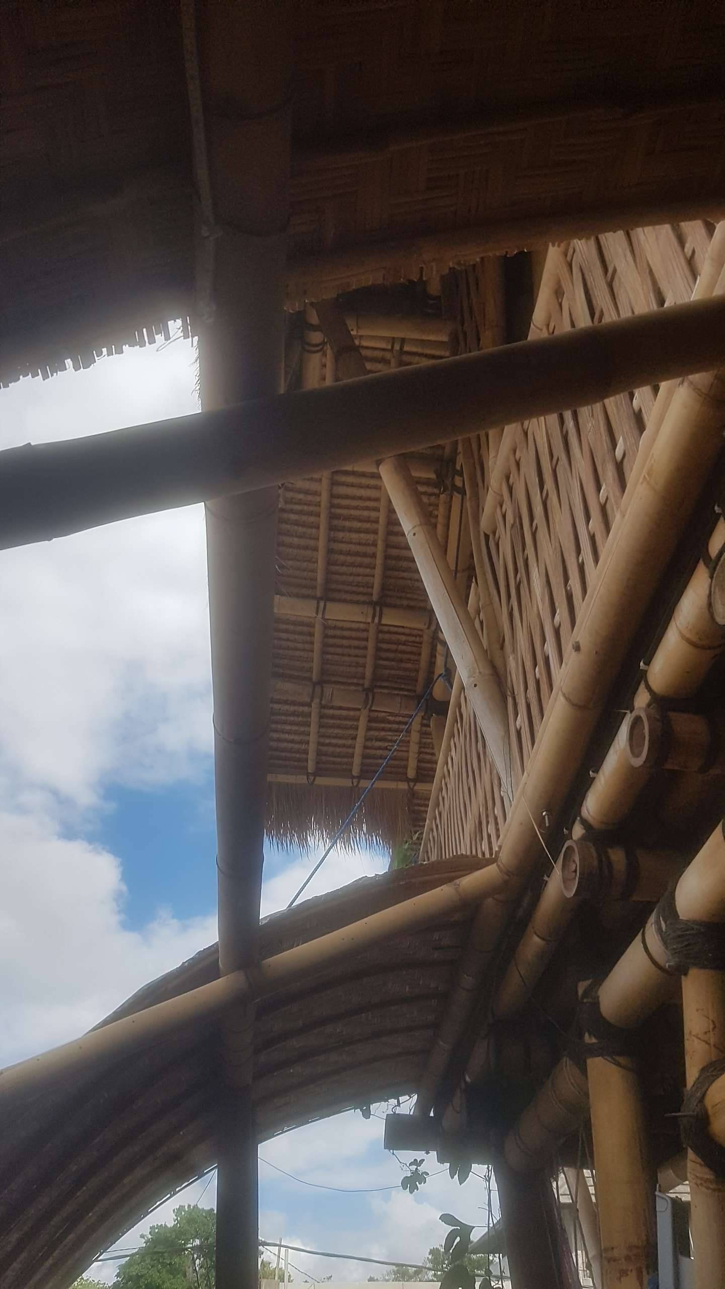 Plastering ‘Bedek’ bamboo woven panel roof with cassava flour glue and ...